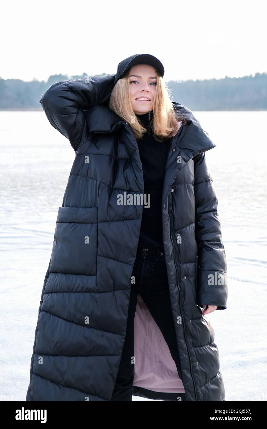 Young female smiling and looking at a camera in a snow landscape. Happy ...