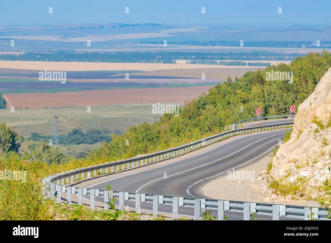 the winding highway with sharp turns and slopes, with warning road ...