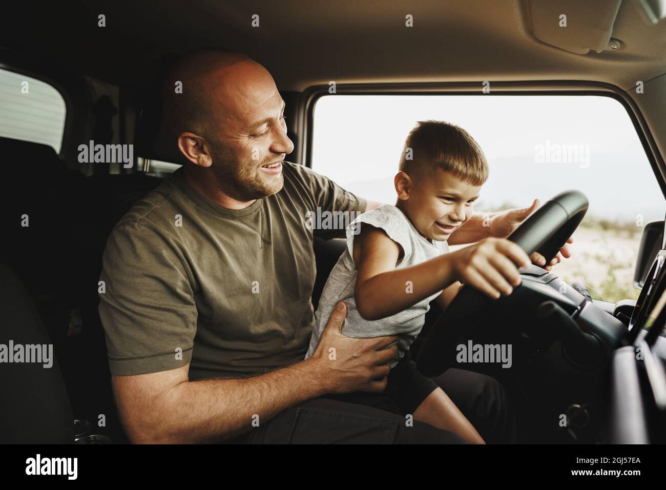 Father teaches little son to drive on road trip Stock Photo - Alamy