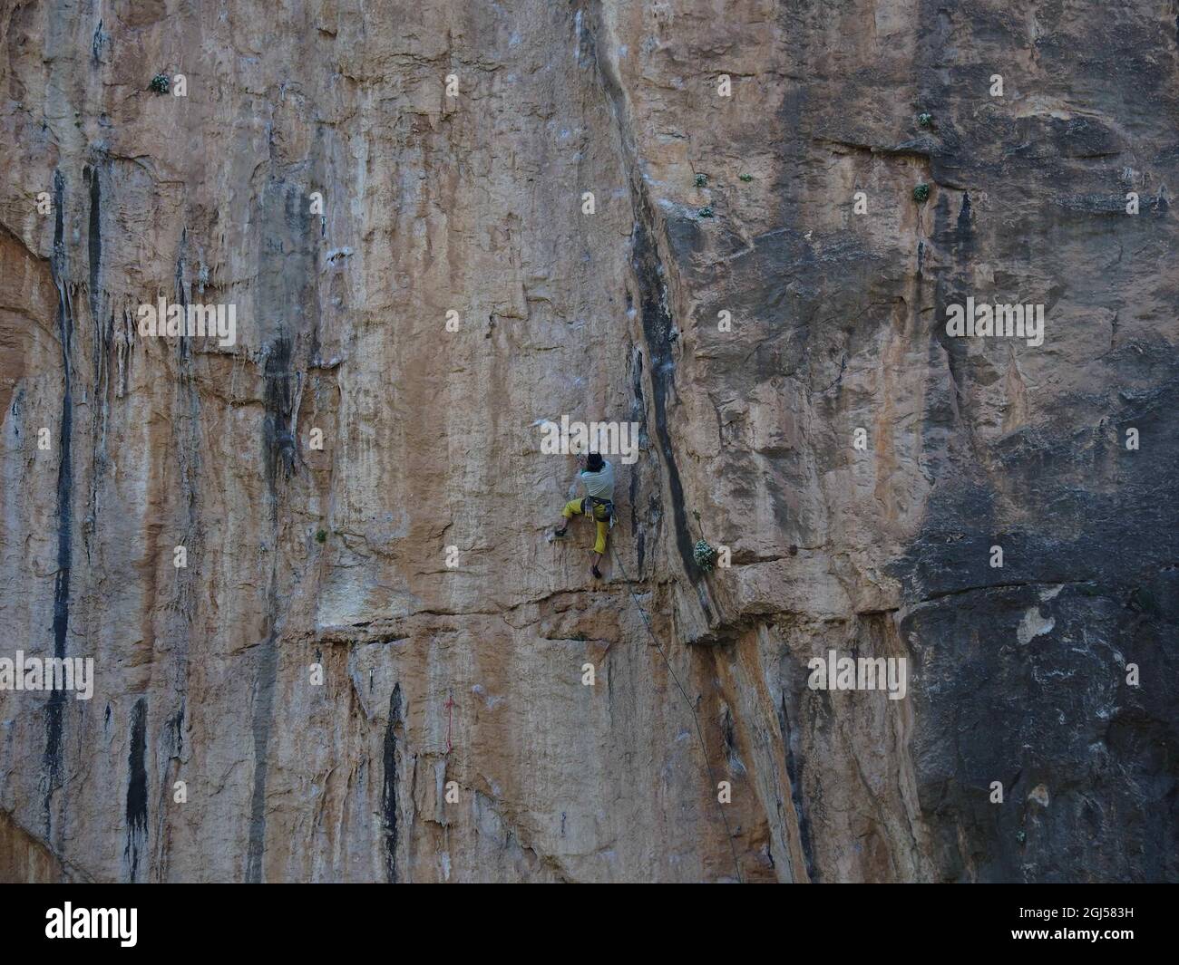 Shot of a person climbing over an old fractured surface of a cliff ...