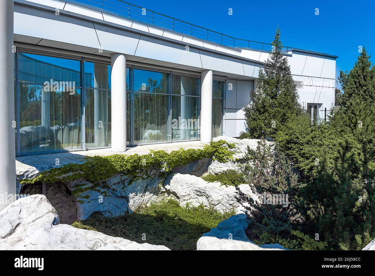 White mansion facade with wide windows and external columns on rocky ...