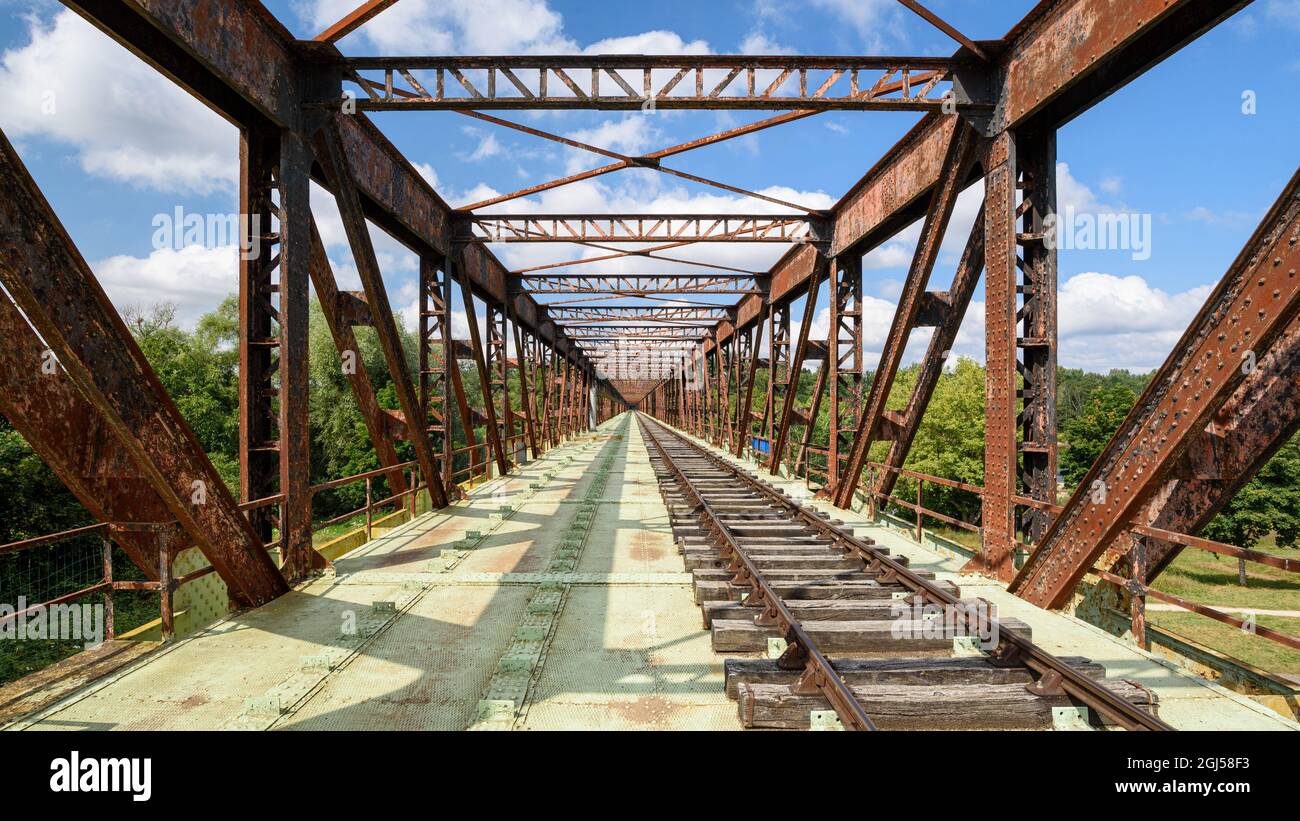 Old railway line crossing a rusty bridge turned into recreational track ...