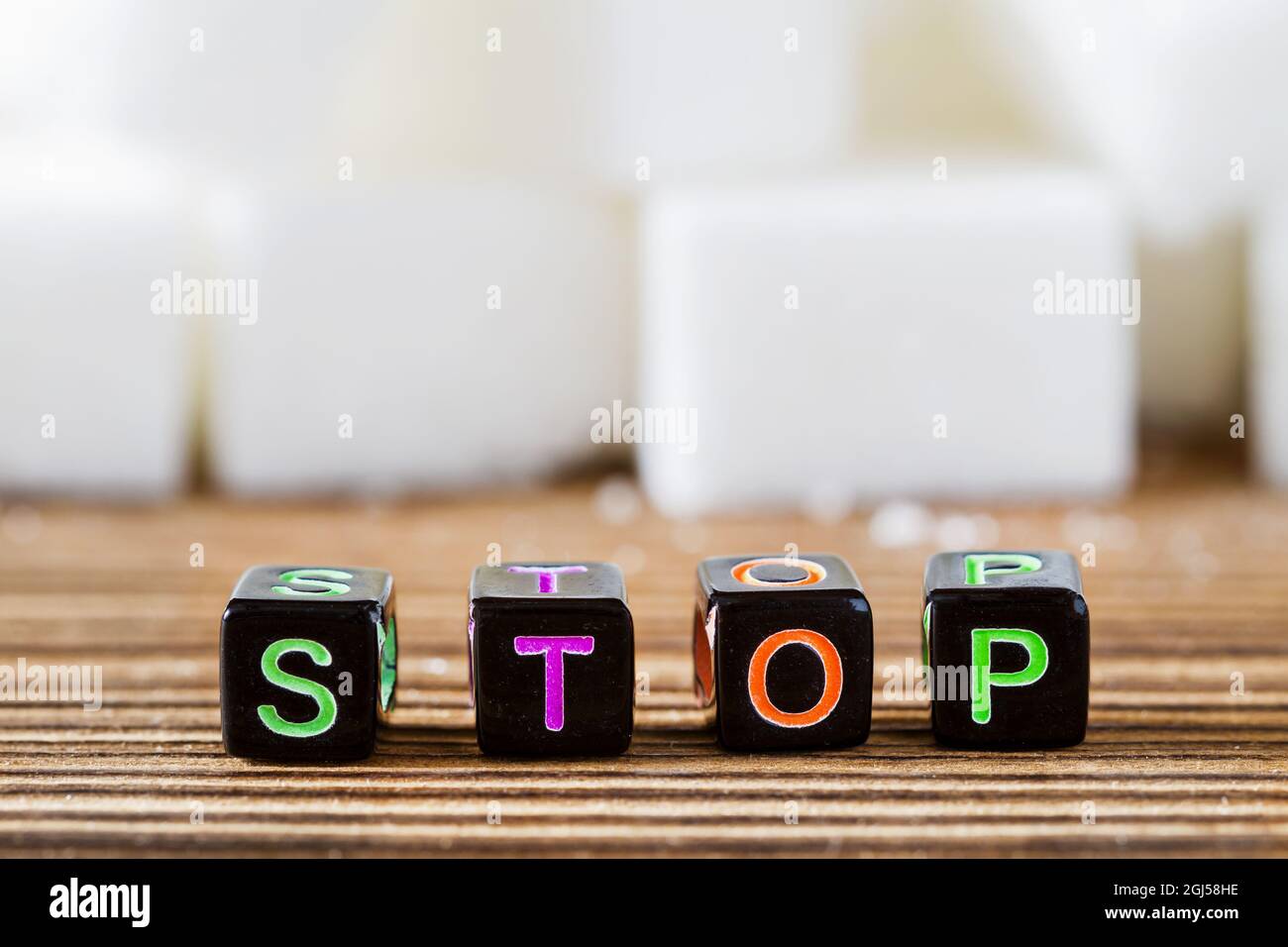 The word STOP on the background of white cubes of sugar. Stop white ...