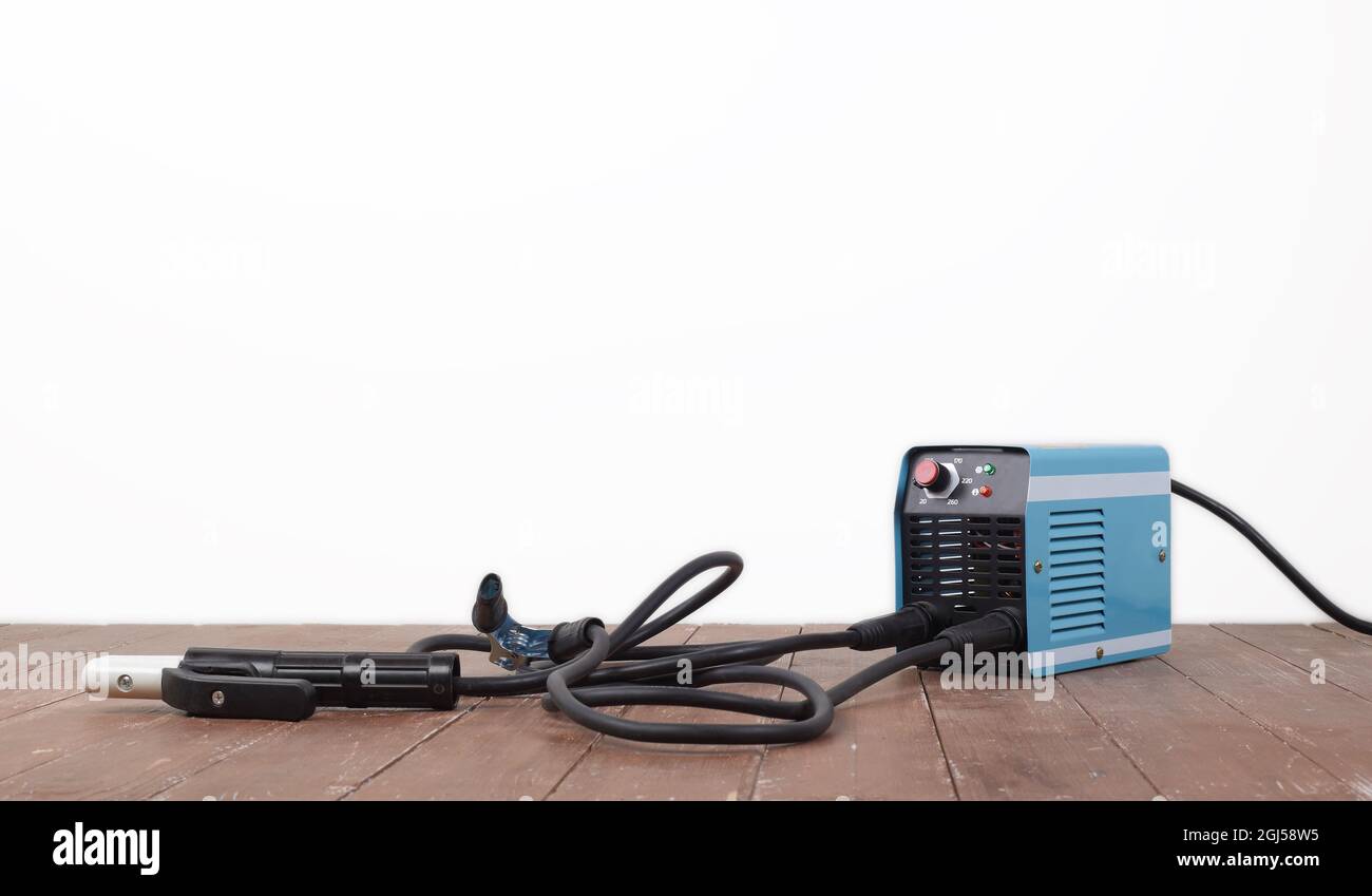 Industrial tool - Welding machine on a wooden and white background ...