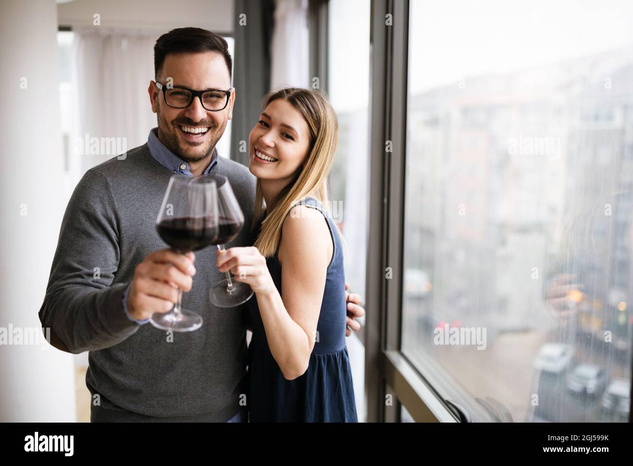 Cheerful happy couple in love drinking wine and having romantic date ...