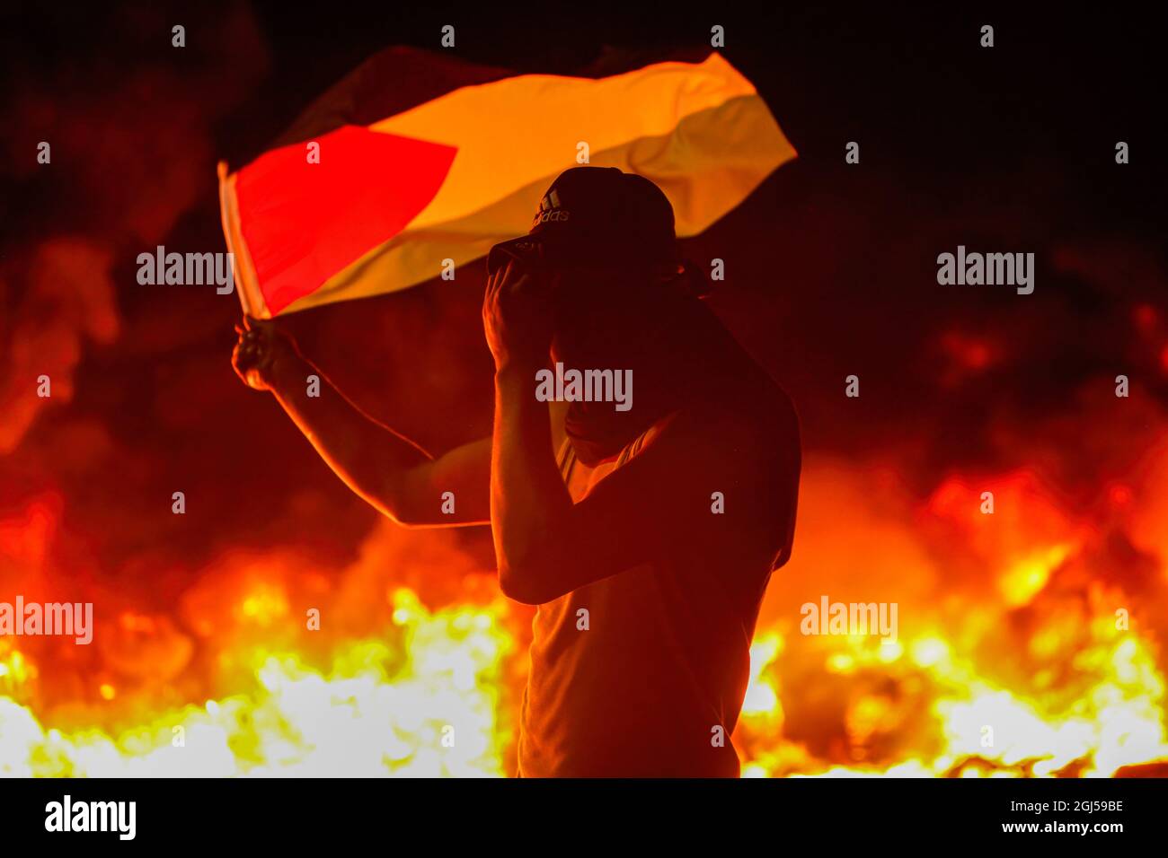 Palestinian demonstrator holds a flag during the confrontation with ...