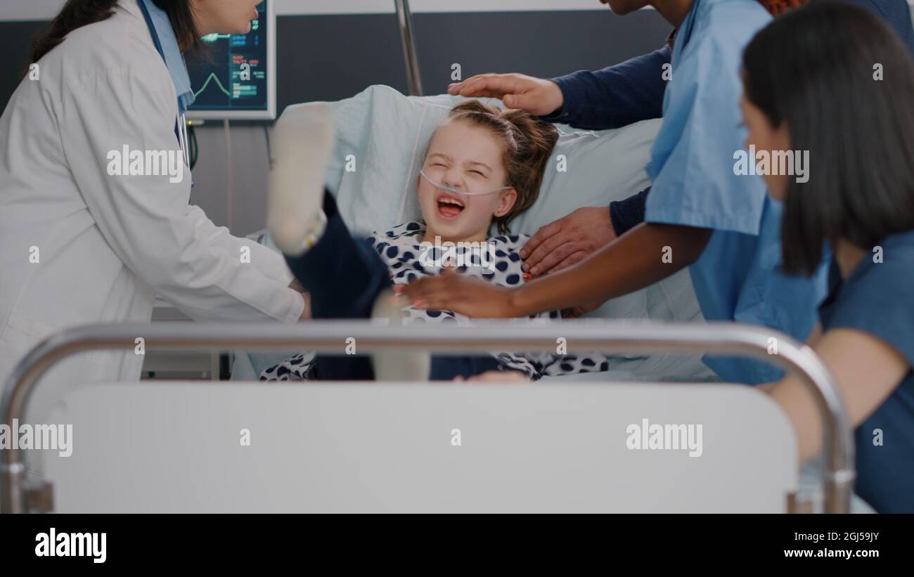 Medcial team trying to stop upset little child while monitoring oxygen ...