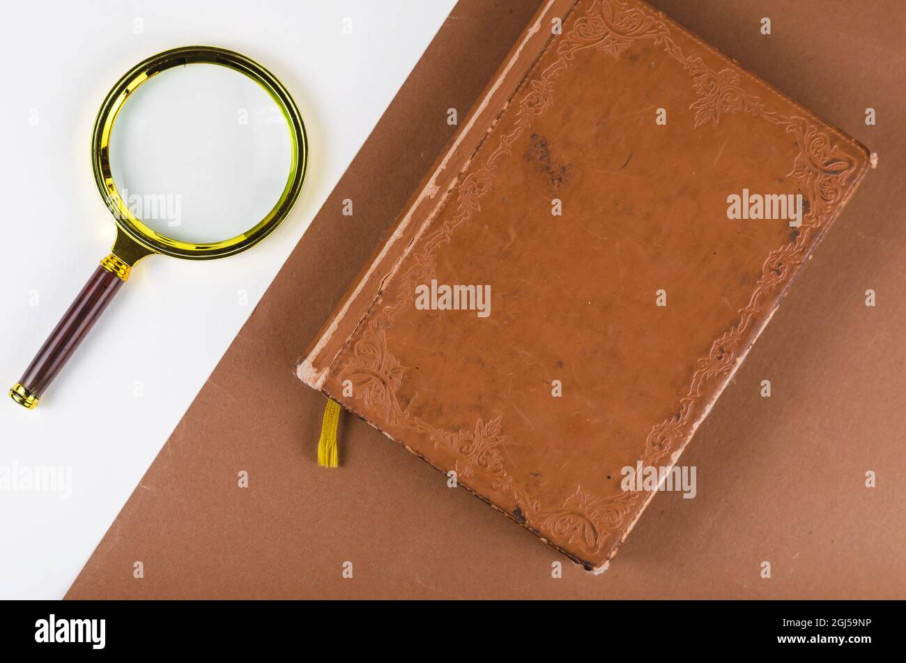 Magnifying glass and an old notebook on a two-color background Stock ...