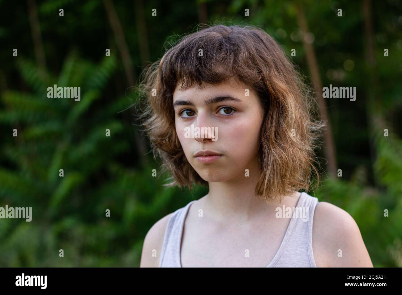 Serious teenager girl looking angry. Curly young girl outside Stock ...