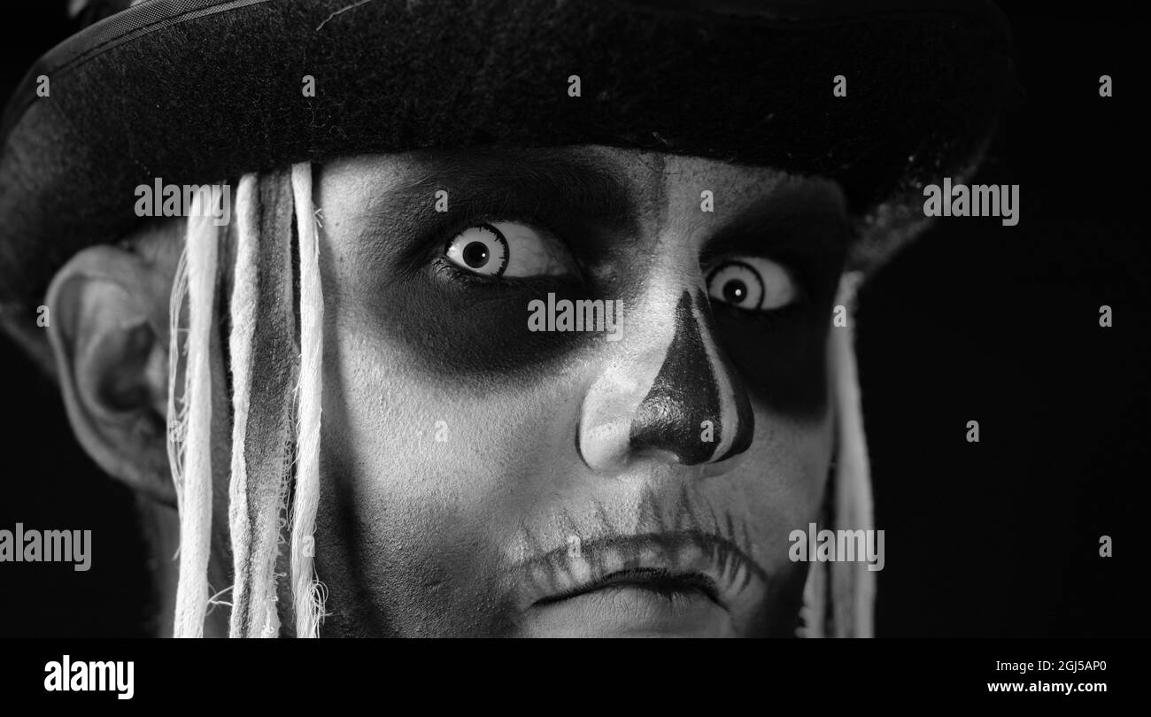 Close-up shot of creepy man in skeleton Halloween makeup opening eyes ...