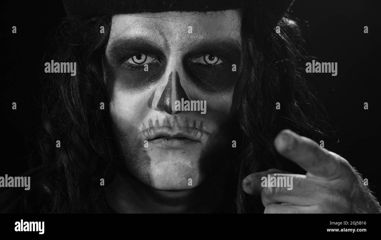 Creepy long hair man with skeleton makeup making faces and pointing at ...