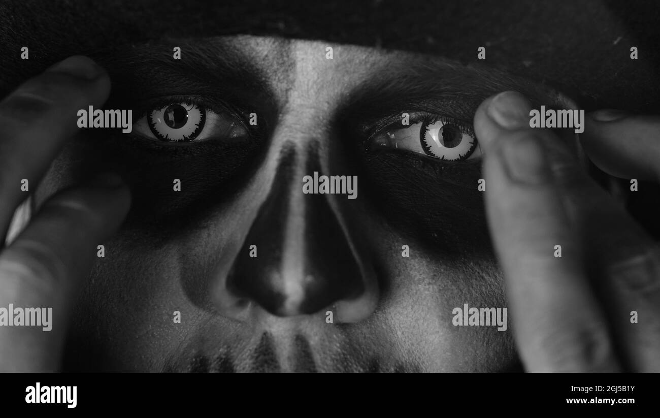 Close-up man face in skeleton Halloween cosplay removing hands from ...