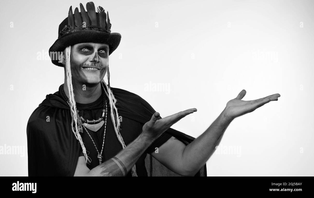 Sinister man with horrible Halloween skeleton makeup ooking at camera ...