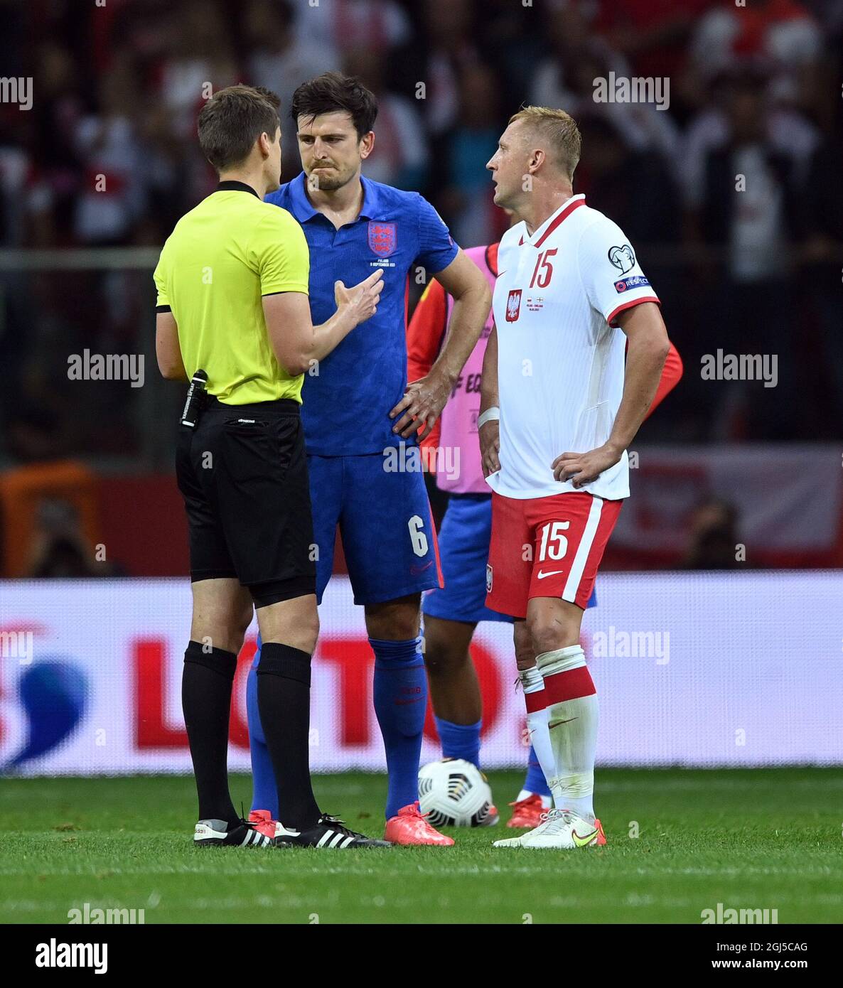 England's Harry Maguire (centre) and Poland's Kamil Glik are spoken to ...