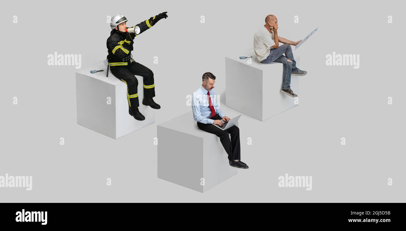 Composite image of three workers sitting on cube isolated on grey ...