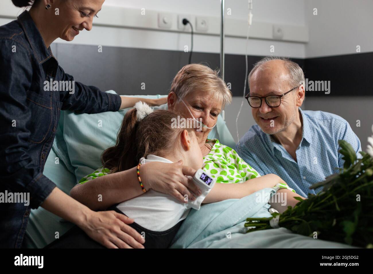 Little granddaughter bringing flowers while visiting sick grandmother ...
