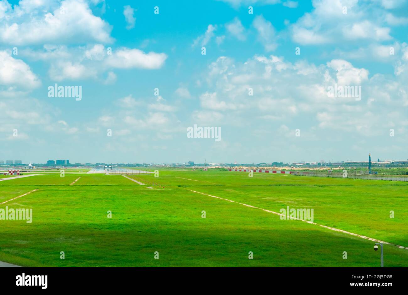 Landscape of the airport runway and green grass field with blue sky and ...