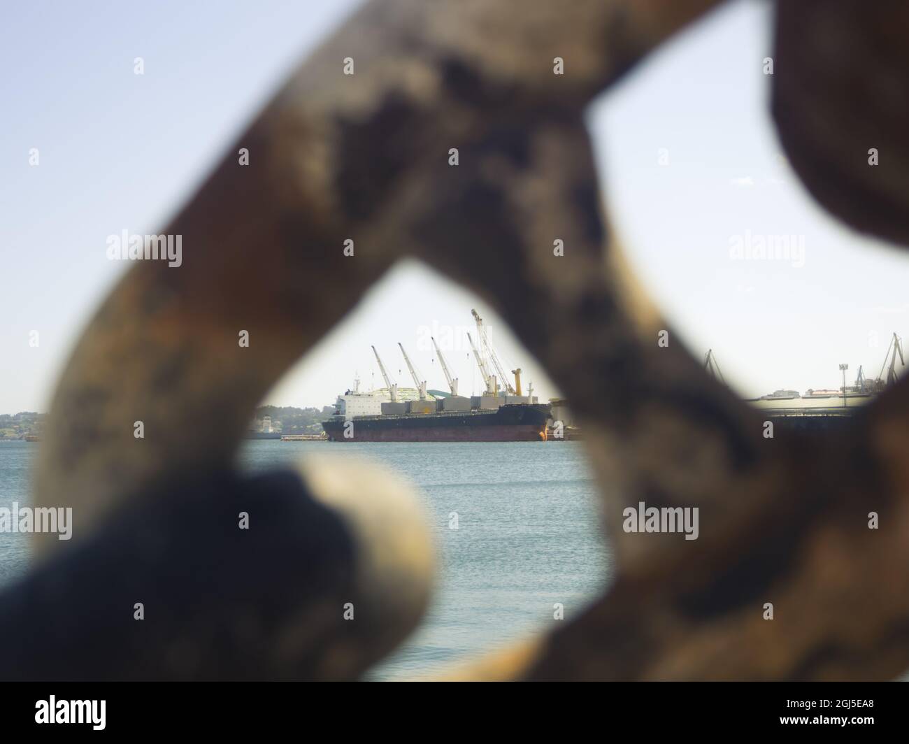 Large ship unloading containers in port as seen through the link of a ...