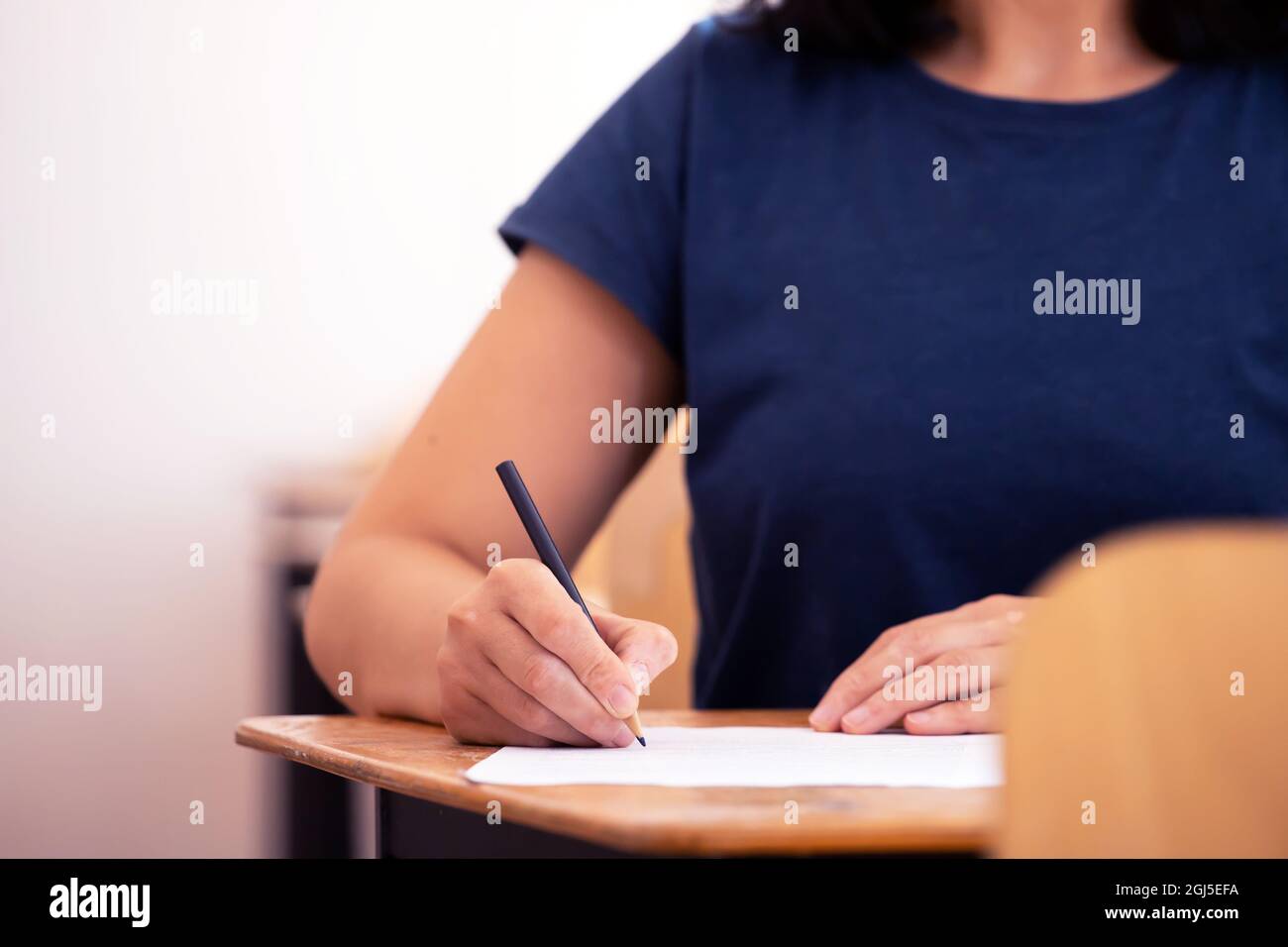 High school or university student holding pencil writing on paper ...