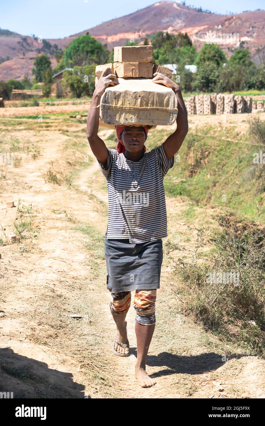 Africa, Madagascar, Antananarivo Province. A woman carrying a large ...