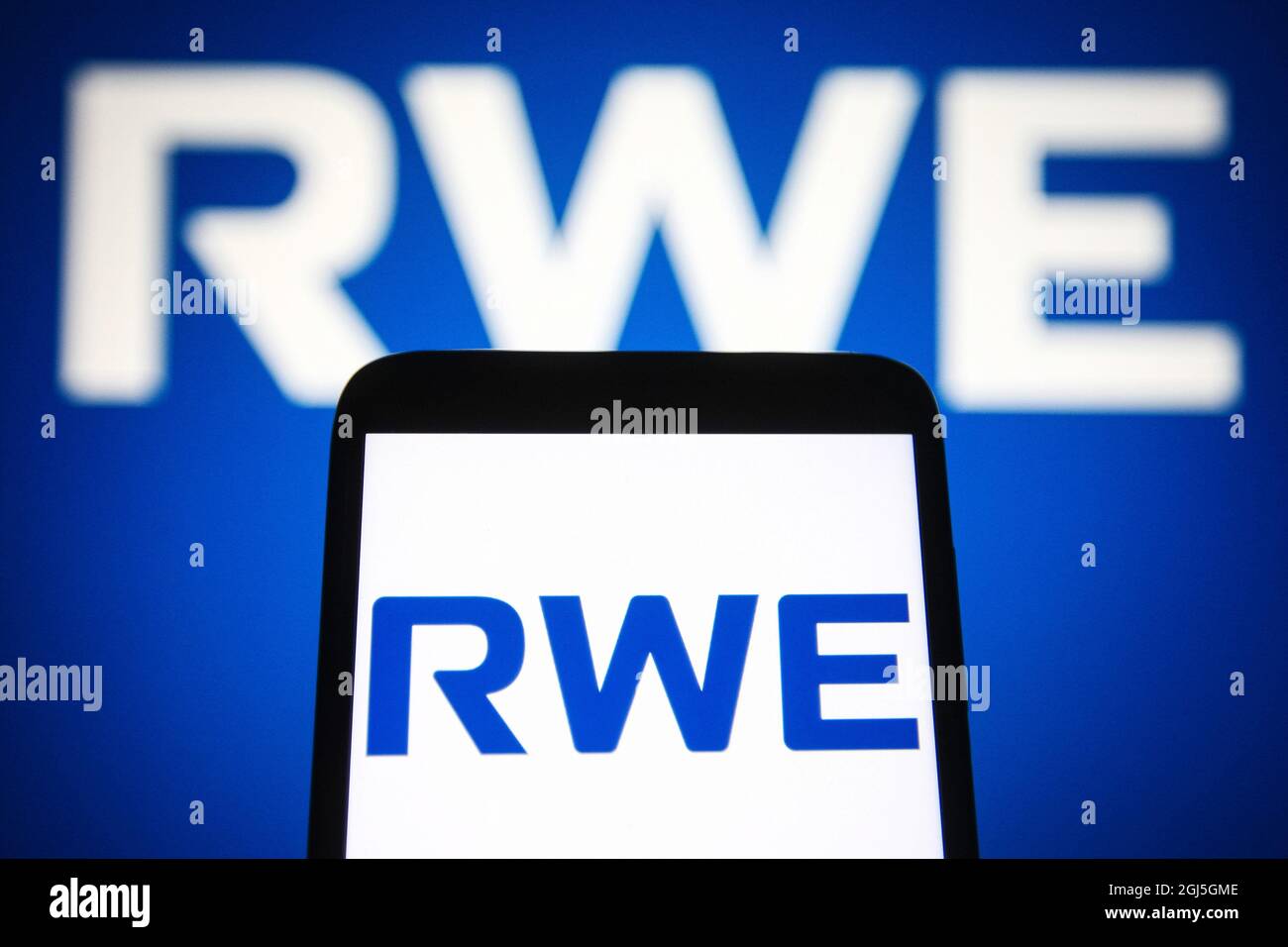In this photo illustration, RWE AG logo is seen on a smartphone and a pc screen. (Photo by Pavlo ...