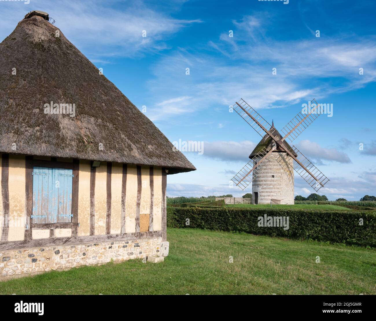 old windmill and traditional farm in french normandy under blue summer ...