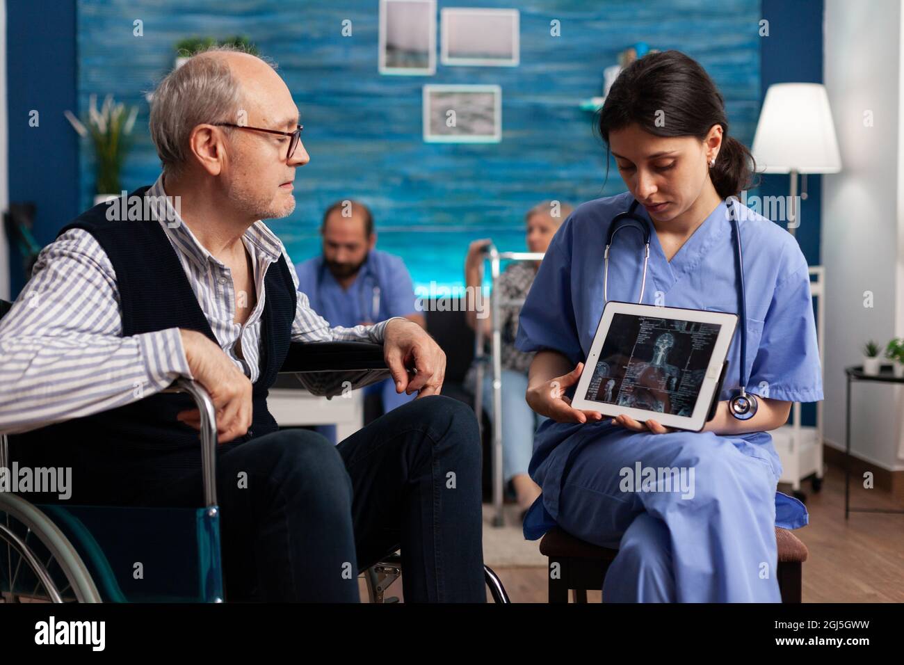 Social nurse worker explaining medical radiography using tablet ...