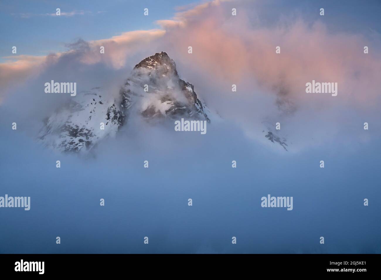 Antarctica, South Georgia Island, Stromness Bay. Cloud-covered mountain at sunset. Credit as ...