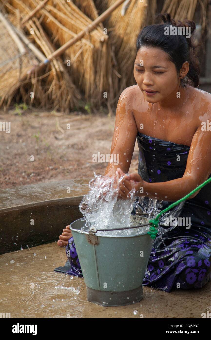 Woman bathing in small town well outside Bagan, Myanmar Stock Photo - Alamy