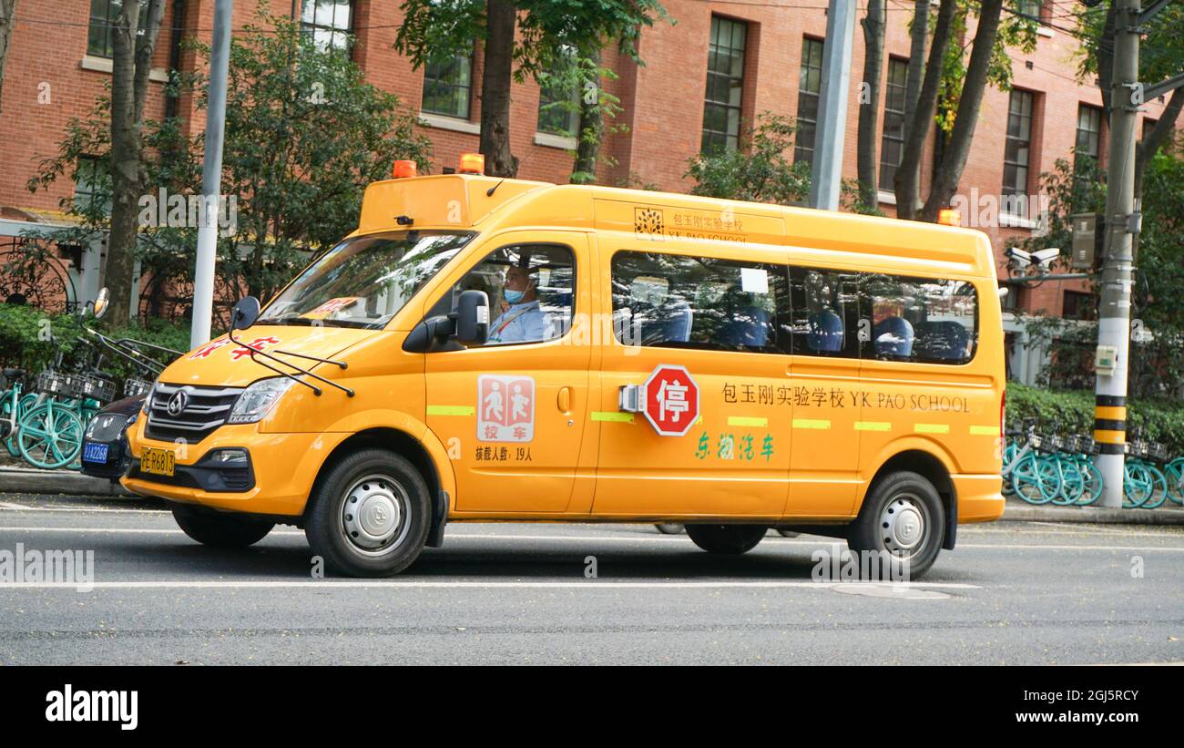 Yellow Chinese school bus on the street, transporting kids after school ...