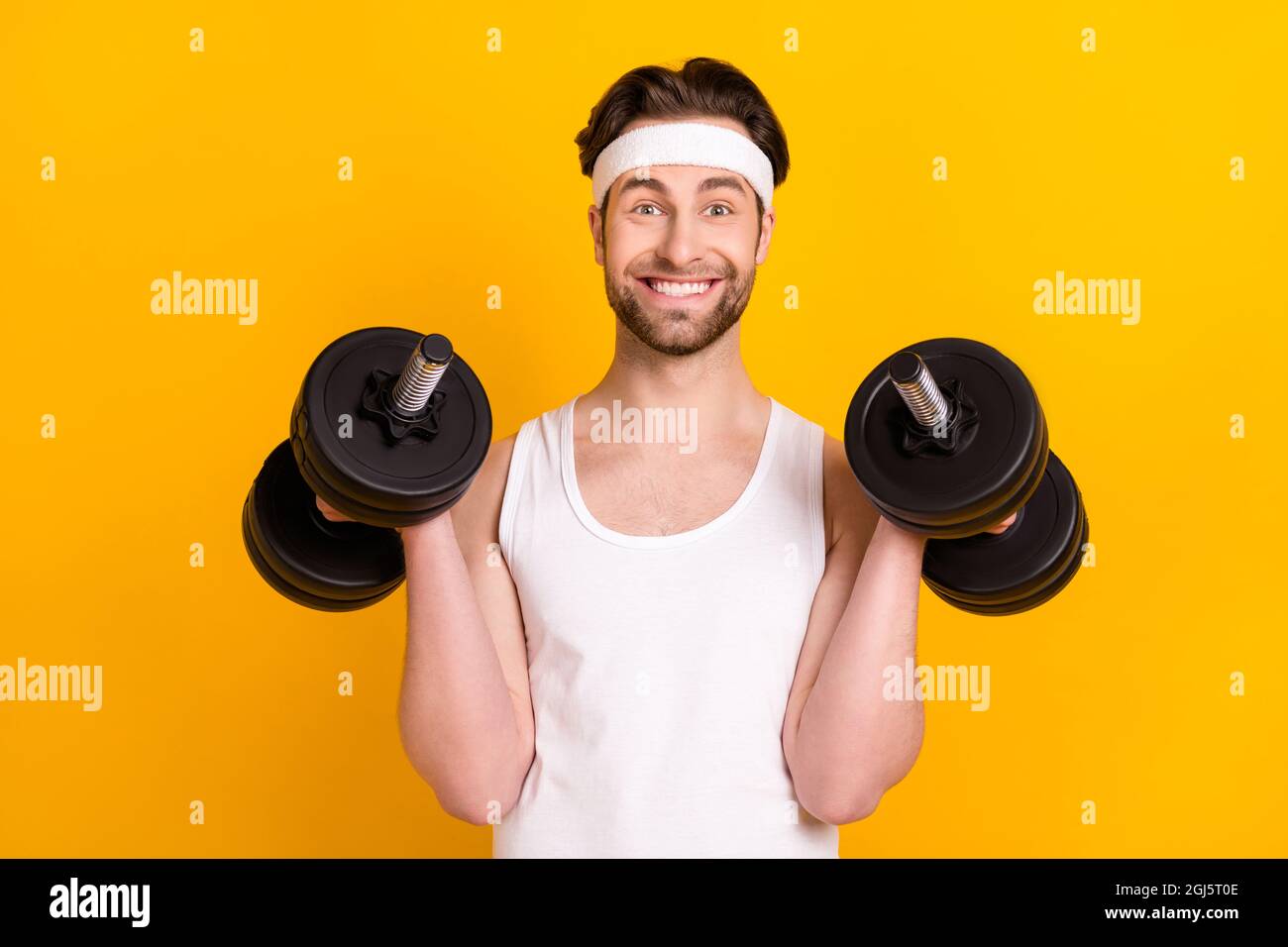 Portrait of attractive glad cheerful guy lifting weight body building ...