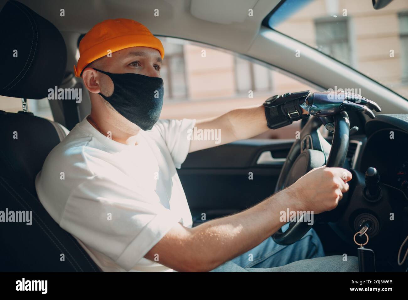 Young disabled man driver with artificial prosthetic hand driving ...