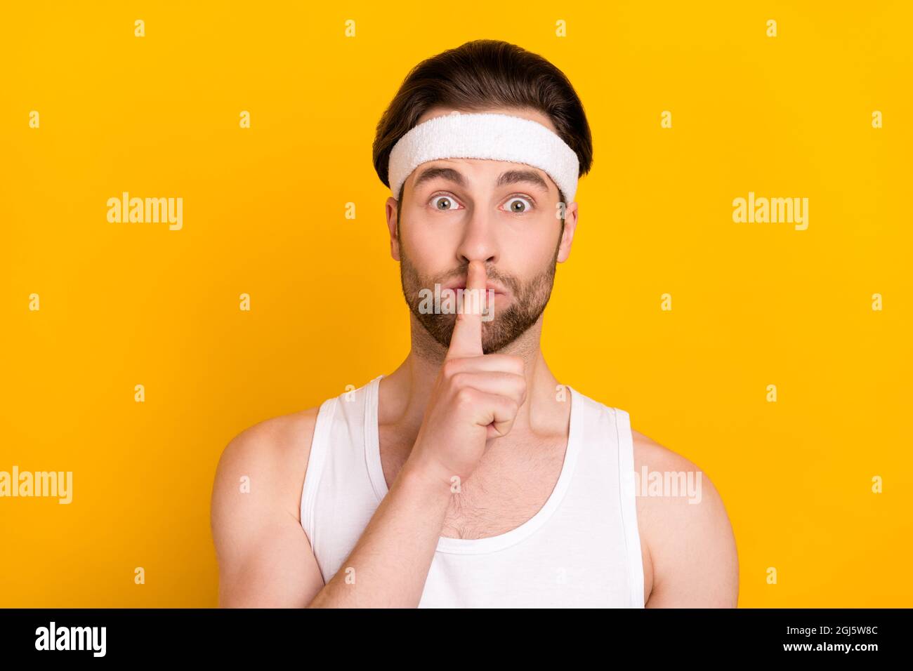 Portrait of attractive mysterious amazed guy sportsman showing shh sign ...