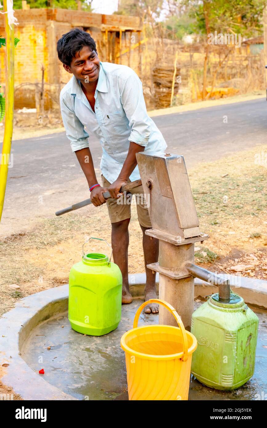 India, Madhya Pradesh. A young man pumps water from a local well Stock ...