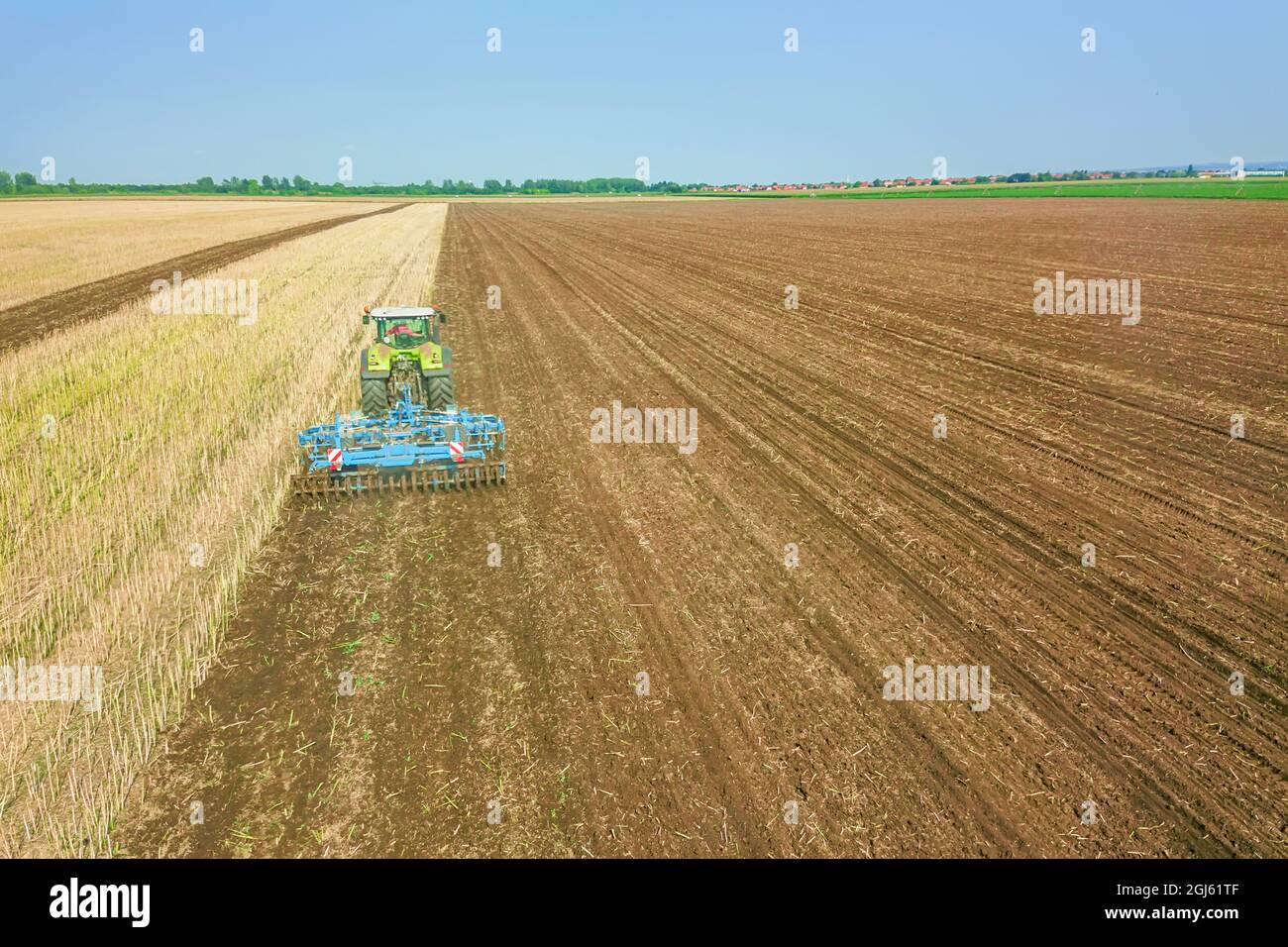 Tractor at work, cultivating a field, Seedbed cultivator Aerial View ...