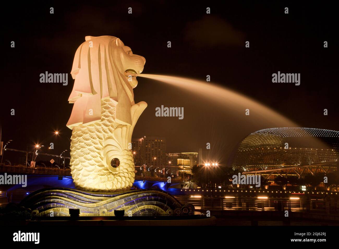 Singapore. Merlion statue spewing water at night Stock Photo - Alamy