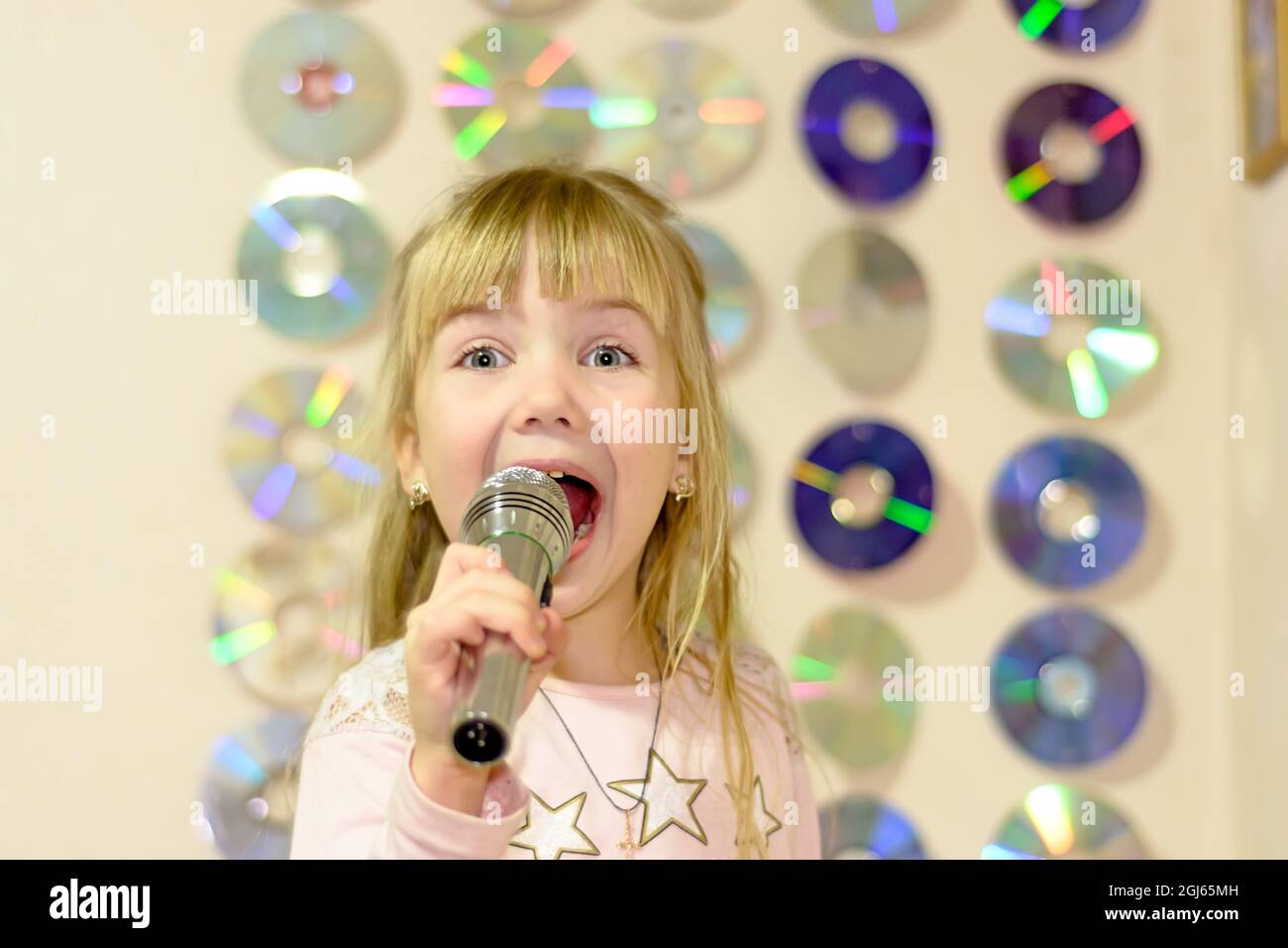 Little girl with microphone sings songs Stock Photo - Alamy
