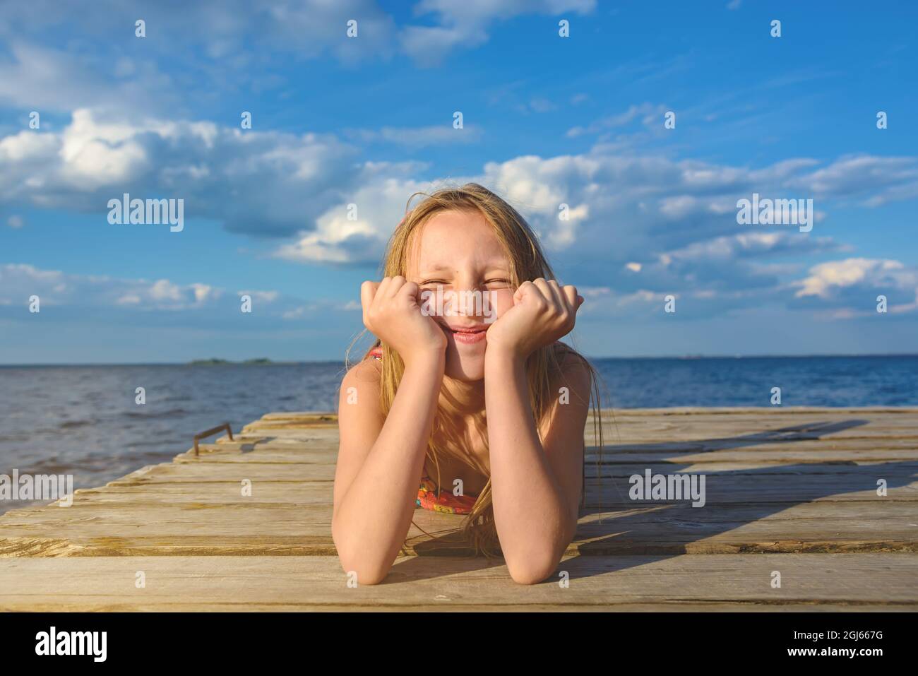 The girl lies on a wooden bridge over the water in a swimsuit Stock ...