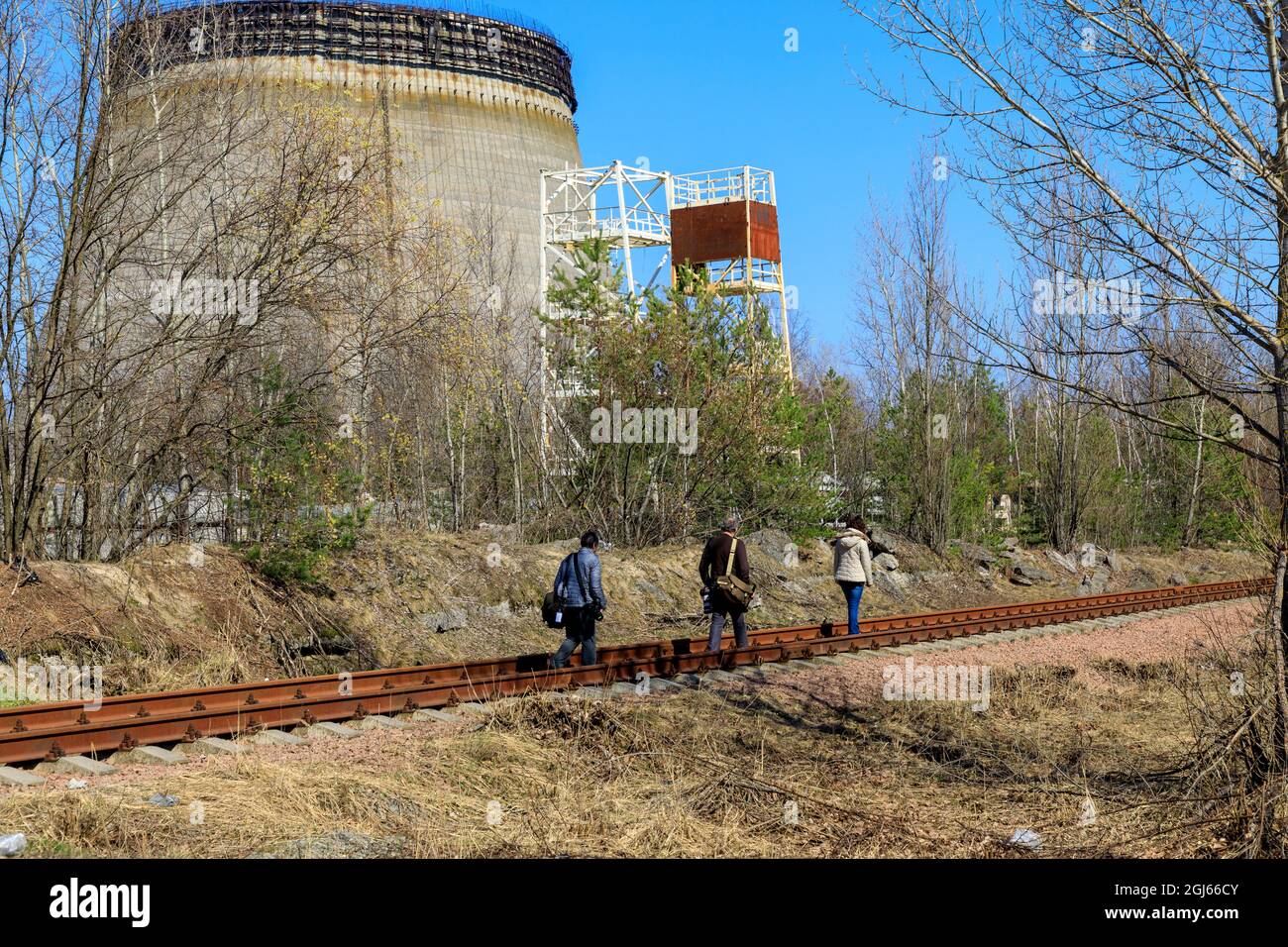Ukraine, Pripyat, Chernobyl. Tourists walking along train tracks near ...