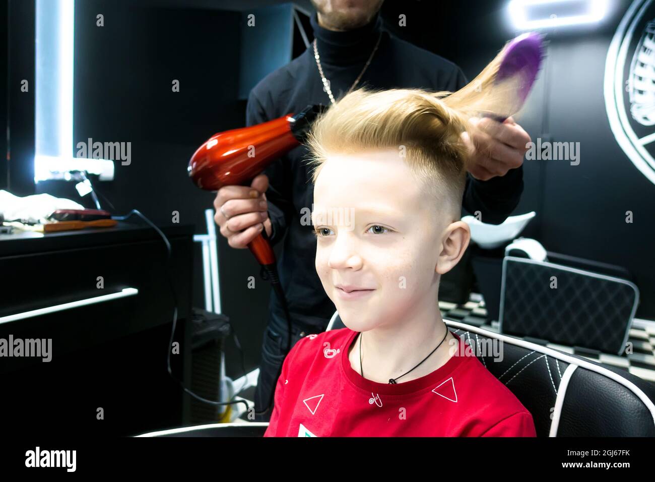The boy dried hair with a hairdryer at the barbershop Stock Photo - Alamy
