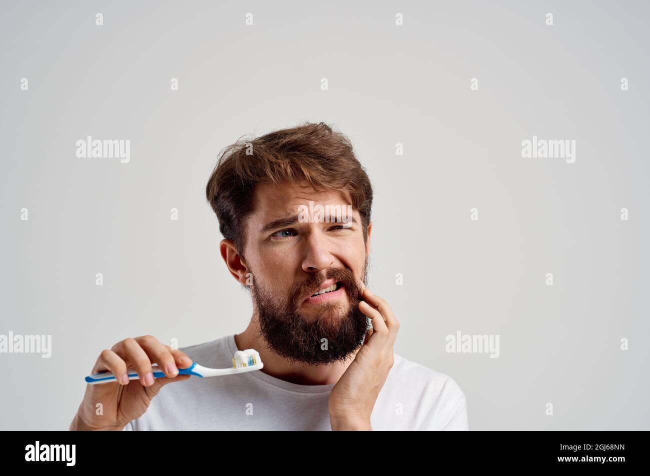 emotional man toothbrush in hand hygiene clean teeth light background ...