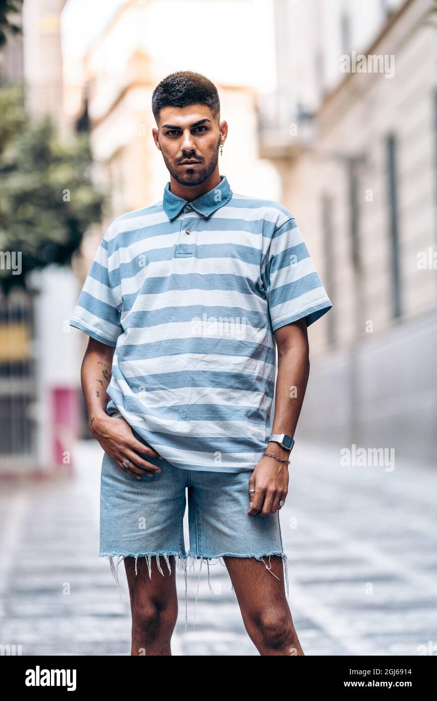 Vertical portrait of a man standing facing the camera in the street ...