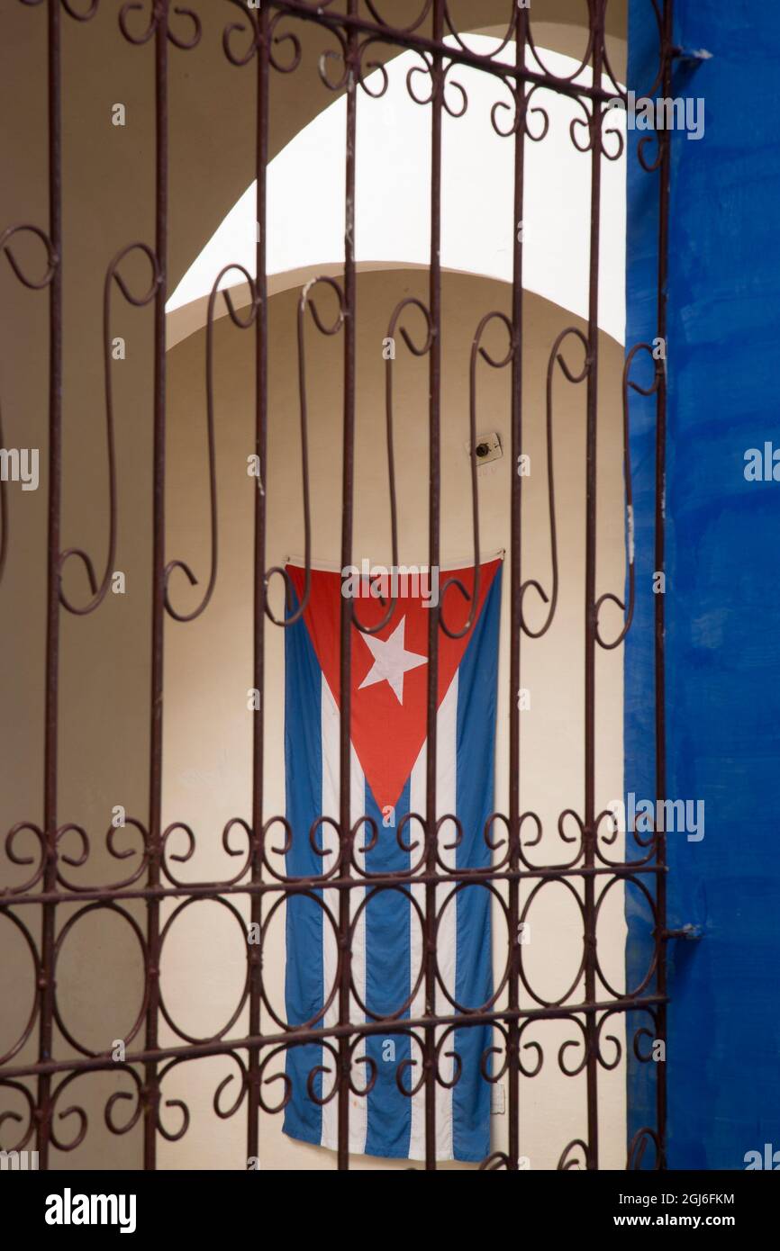 Cuba, Vinales, Cuban flag in courtyard and wrought iron gate Stock ...
