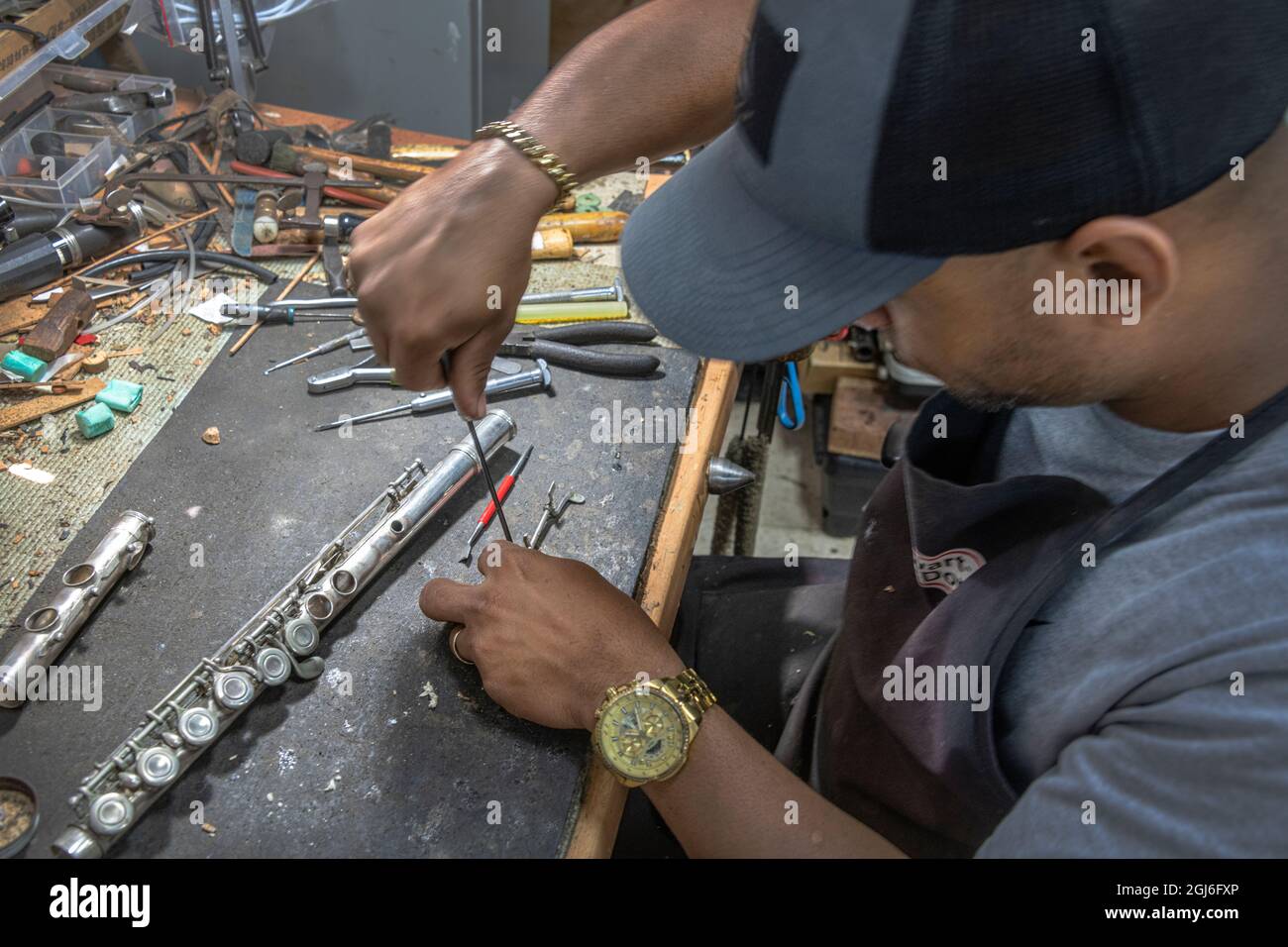 Close-up of craftsman fixing a flute in the wind instrument repair shop ...