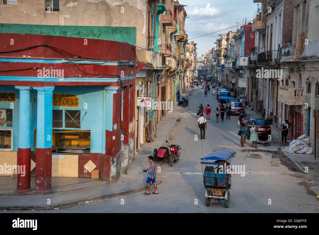 Morning light hits colorful building on corner of street scene in ...