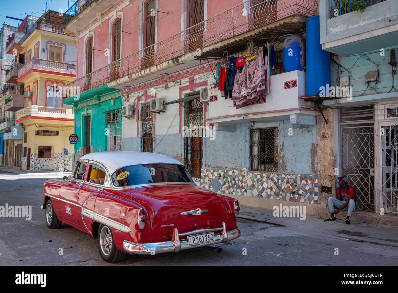 A red classic American Chevy driving on residential street in Central ...