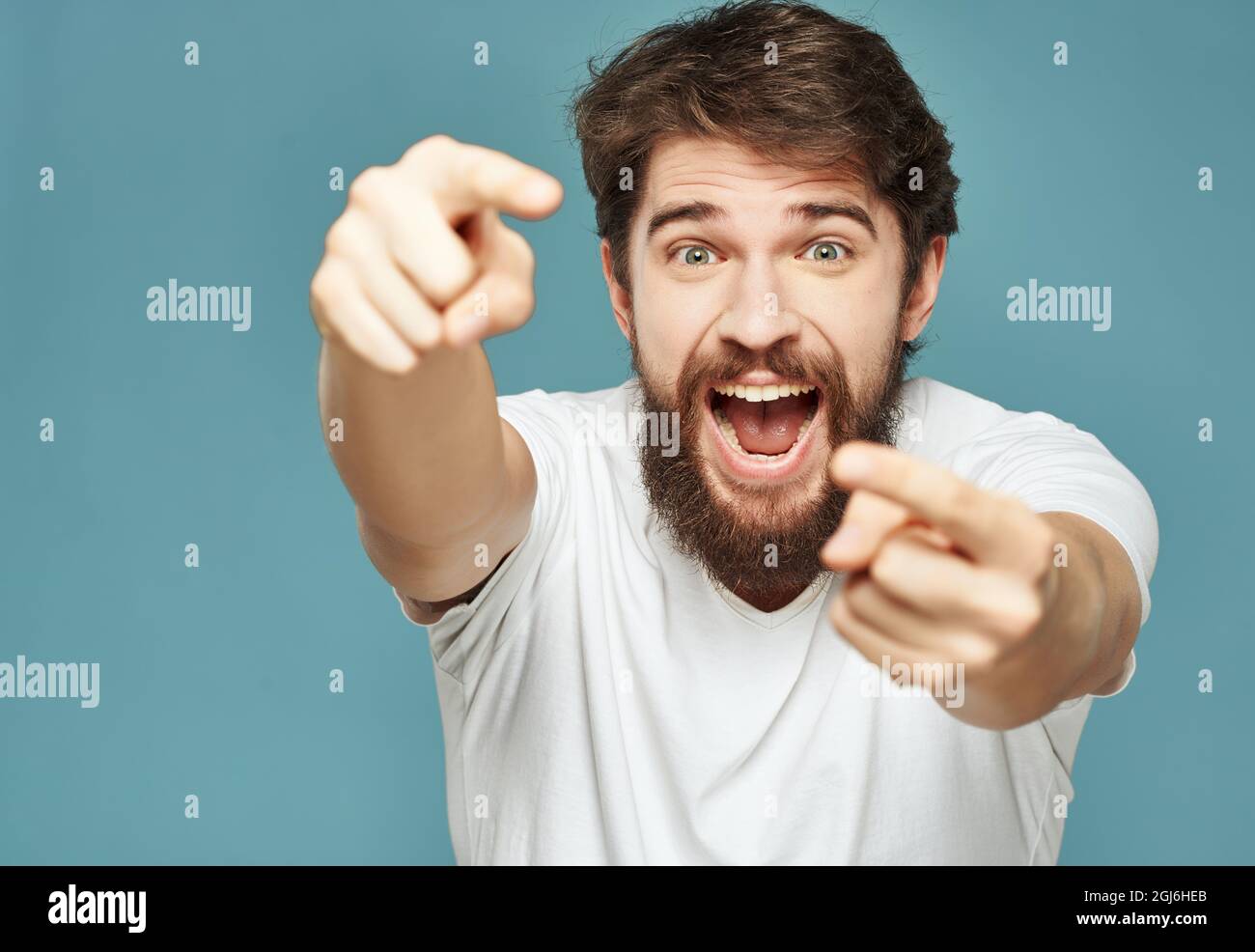 Man in a white t-shirt irritated facial expression yellow background ...