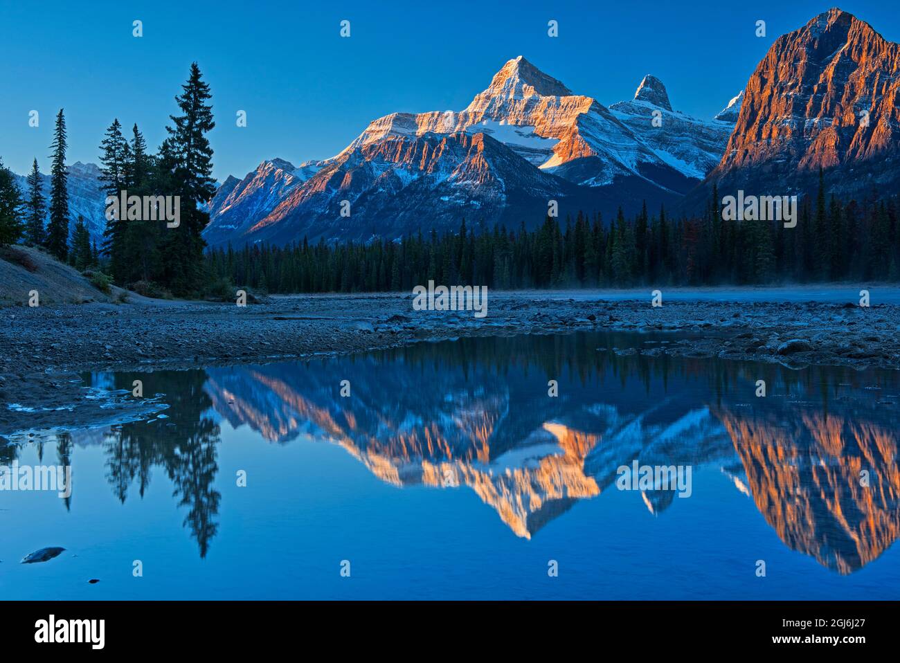 Canada, Alberta, Jasper National Park. Mountains reflected in river at ...