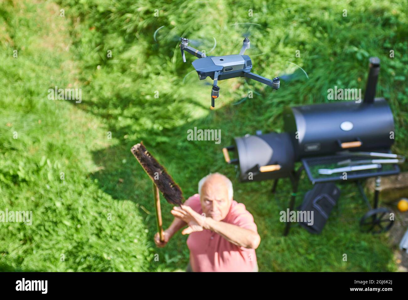 Název: Old senior man upset by a flying drone over his garden. The ...