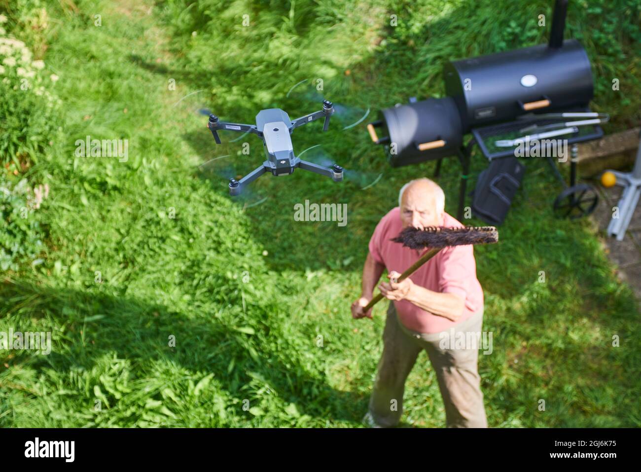 Název: Old senior man upset by a flying drone over his garden. The ...